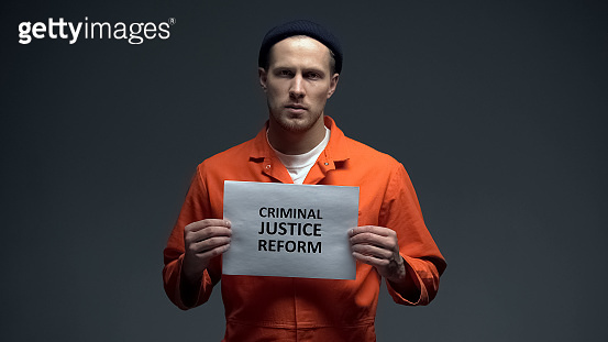 Male prisoner holding Criminal justice reform sign, human rights ...
