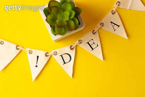 Idea word written on textile, decorative garland with succulent flower ...