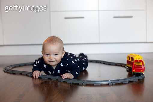 Little baby boy, playing with train and railroad at home 이미지 ...