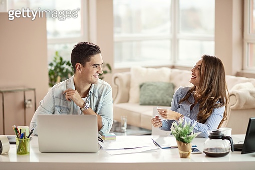 Young business couple laughing and having fun while working in the ...