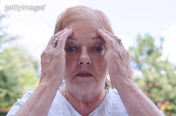 Stressed senior woman head shot,holding hands on head having memory ...