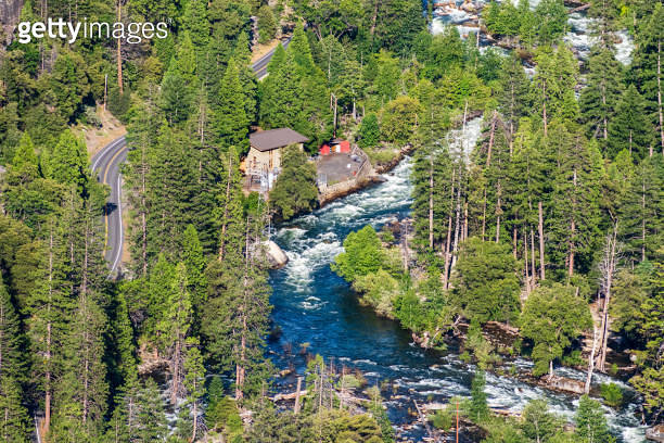 Aerial view of Merced river flowing through a coniferous forest ...