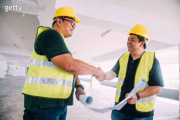 Engineer and contractor successful deal handshake on construction site ...