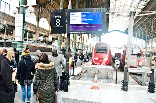 Tourists and travellers on platform 8 looking at the arrival departure ...
