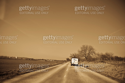 A minivan driving on an empty German motorway with beautiful farmland ...