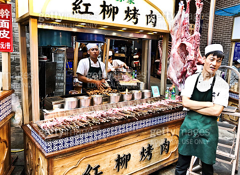 A Chinese fresh beef and pork meat vendors waiting for customers in a ...