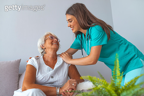 Helpful volunteer taking care of senior lady at healthcare home 이미지 ...
