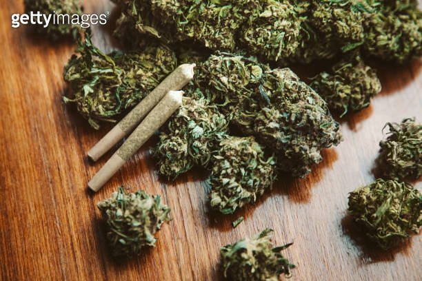 Marijuana joints with cannabis laying on wooden table at cannabis shop ...