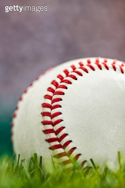 Close-up of a baseball sitting in the outfield grass of a stadium 이미지 ...