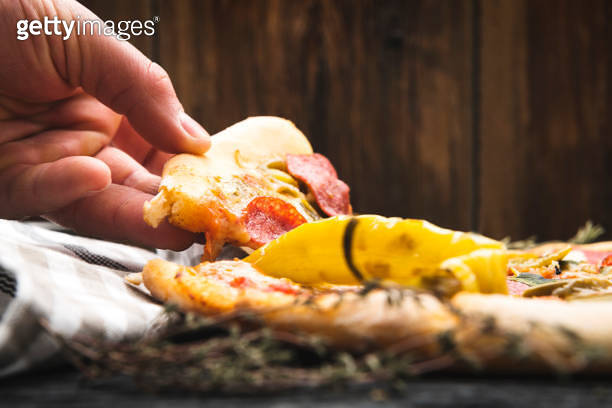 Human hand picking slice of pepperoni pizza (1093961852) - 게티이미지뱅크