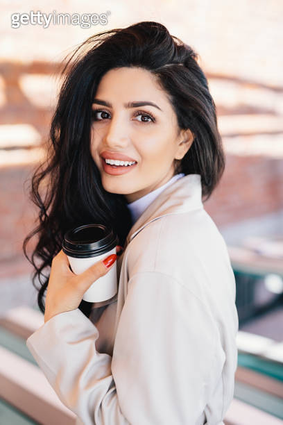 Vertical portrait of charming luxurious young lady with dark voluminous ...