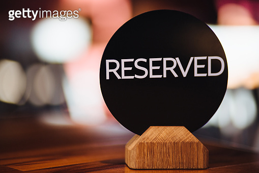 Close up of restaurant reserved table sign on table. Inscription ...