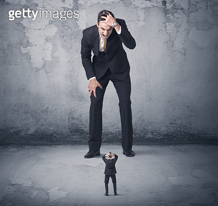 Big business bully looking at small coworker 이미지 (1138415421) - 게티이미지뱅크