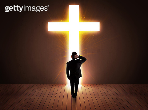 Man looking at bright cross sign 이미지 (1124475181) - 게티이미지뱅크