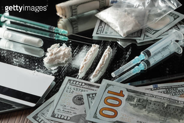 A bunch of different drugs, syringes, pills on the table. Social ...