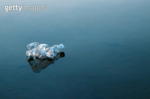Concept of pollution, creative background. A plastic bottle floating in ...