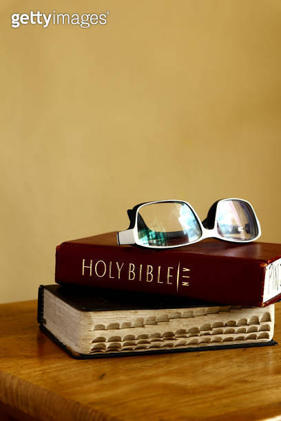 Holy Bibles on a table and eyeglasses 이미지 (1169174915) - 게티이미지뱅크