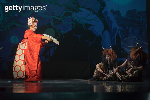 Traditional Japanese performance. Actress in red dancing with fan ...