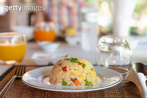 fried rice on a white plate and orange juice (1161185412) - 게티이미지뱅크
