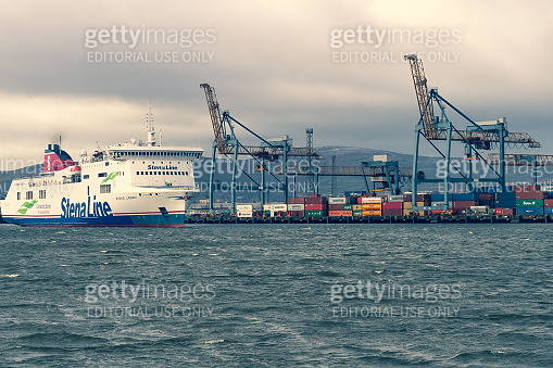 A cargo and passenger ferry passes the shipping container dock at ...