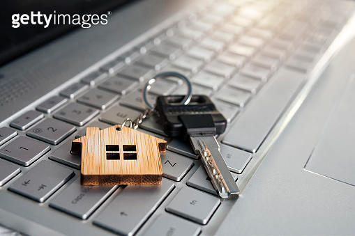 Mortgage concept with keys and house-shaped key ring on laptop keyboard ...