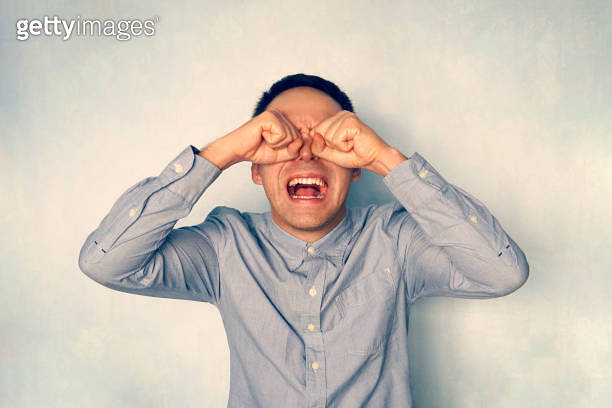 A grown man in a blue shirt screams and cries. Negative emotion. People ...
