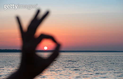 Hand gesture ok. The sun rises over the bay. Focus on the sun. 이미지 ...