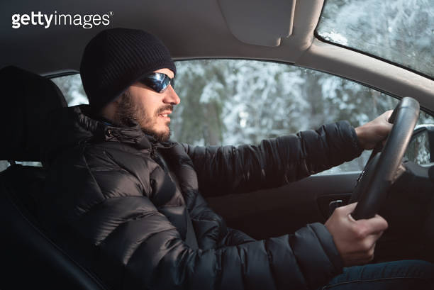 Driver driving in winter clothes. Side view. Winter outside. 이미지 ...