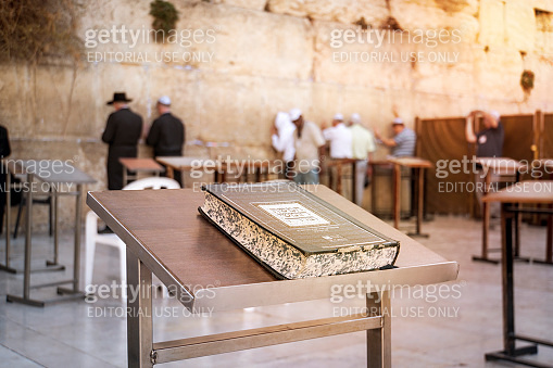 Jewish bible - Torrah on table on blurred background of praying Jews ...