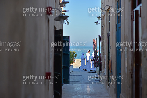 Three qatari men walking in Wakrah old souq, Qatar (1176633352) - 게티이미지뱅크