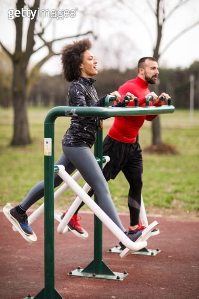 Young sportspeople training together on a walking machine placed in a ...