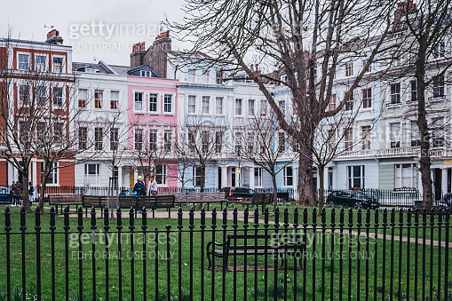 People in Chalcot Square Gardens, colourful terraced houses of Primrose ...