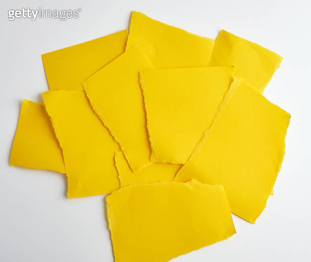 stack of yellow paper torn pieces of paper on a white background 이미지 ...
