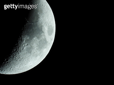 a very sharp close-up of the rising crescent moon in the night sky ...