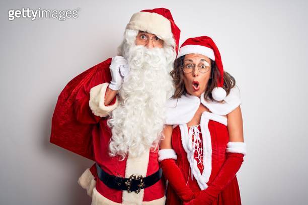 Senior couple wearing Santa Claus costume holding sack over isolated ...
