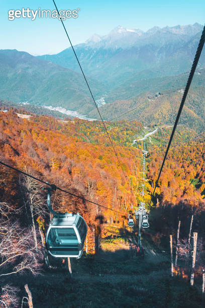 Cableway with cabins for tourists, a view of the town and the autumn ...