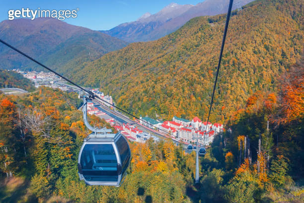Cableway with ski lifts and cabins for tourists, a view of the town and ...