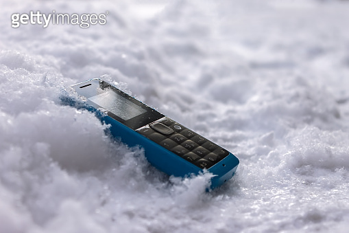 Lost mobile phone lying on the road in the snow 이미지 (1135030110) - 게티이미지뱅크