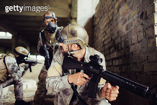 A picture of guy looking for an aim. He is loooking through loop gun ...