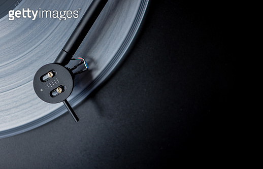 Modern round headshell with black cartridge on straight tonearm and ...