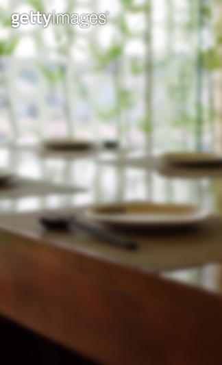 Defocused empty japanese restaurant table setting with plates and ...