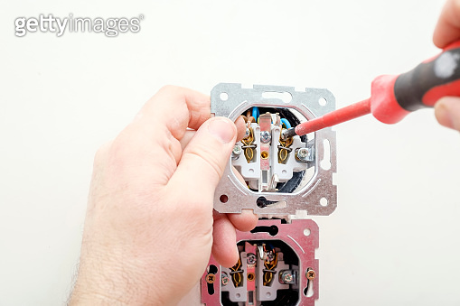Electrician hand holds socket in process installation or repairing with ...