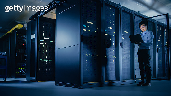 In Data Center: Male IT Technician Running Maintenance Programme on a ...