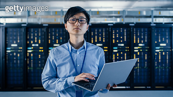 In the Modern Data Center: Portrait of IT Engineer Standing with Server ...
