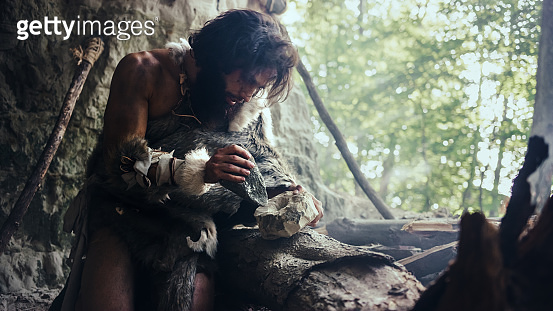 Primeval Caveman Wearing Animal Skin Hits Rock with Sharp Stone and ...