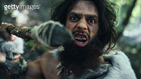 Portrait of Primeval Caveman Wearing Animal Skin and Fur Hunting with a ...