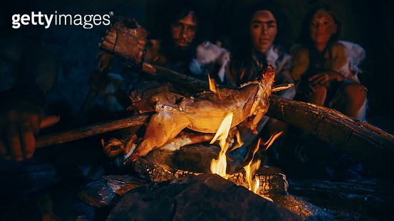 Neanderthal or Homo Sapiens Family Cooking Animal Meat over Bonfire and ...