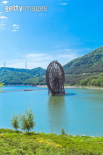 Large wooden waterwheel and blue water, Xijiao National Forest Park ...