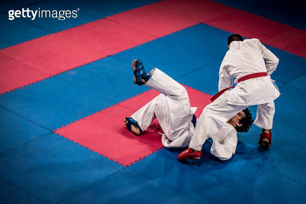 Karate practitioner punching his opponent on the ground (1157706020 ...