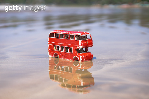 Red toy bus in nature pollutes the earth's ecosystem. English bus ...